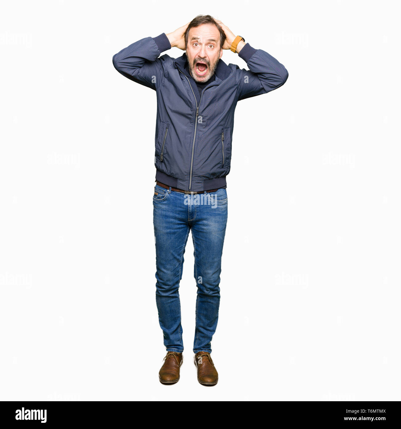Middle age handsome man wearing a jacket Crazy and scared with hands on ...