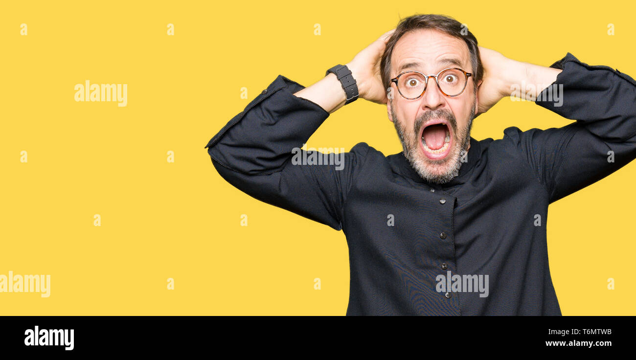 Middle age priest man wearing catholic robe Crazy and scared with hands ...
