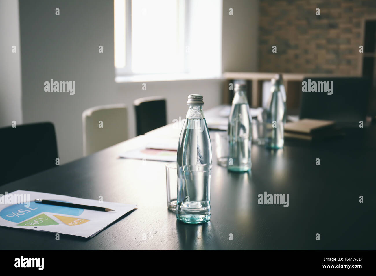 Table with bottles of water prepared for business meeting in conference ...