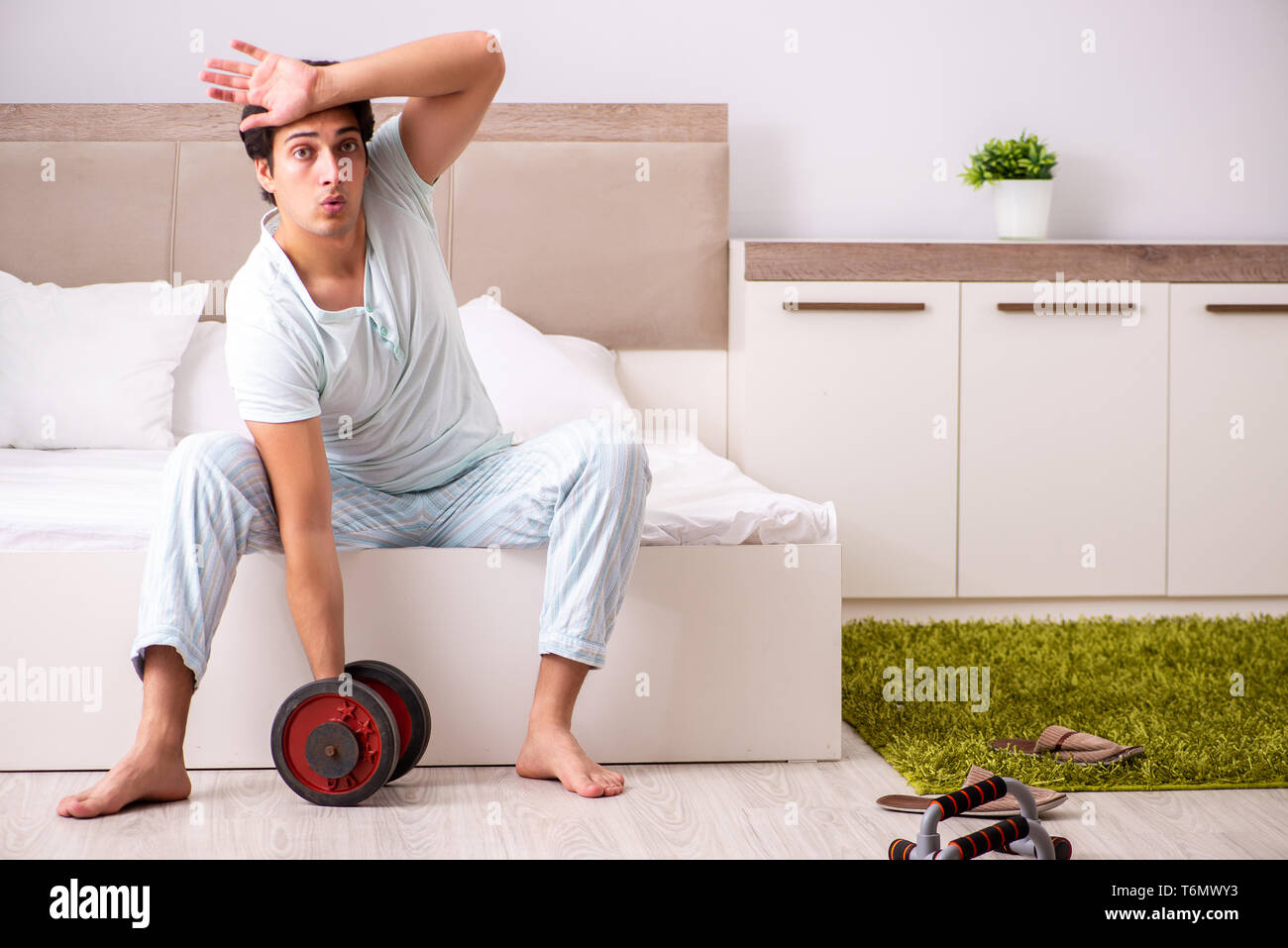 Young man doing morning routine in bedroom Stock Photo - Alamy