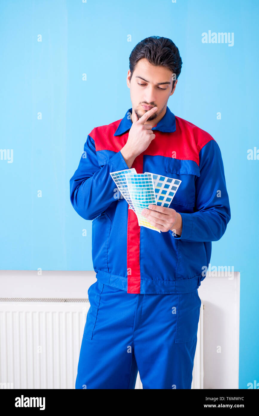 Young man contractor choosing color from rainbow Stock Photo - Alamy