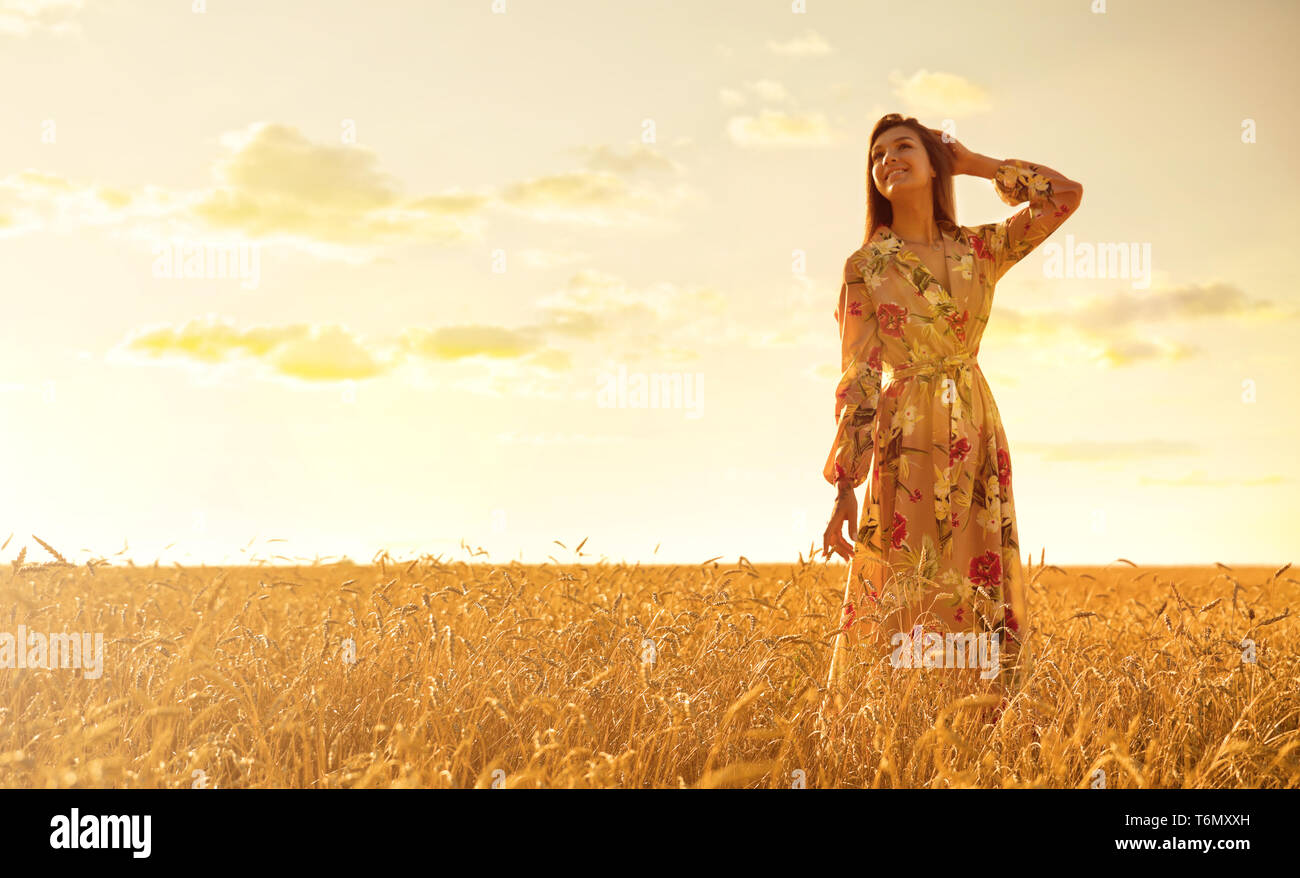 Young girl in wheat field at sunset Stock Photo - Alamy