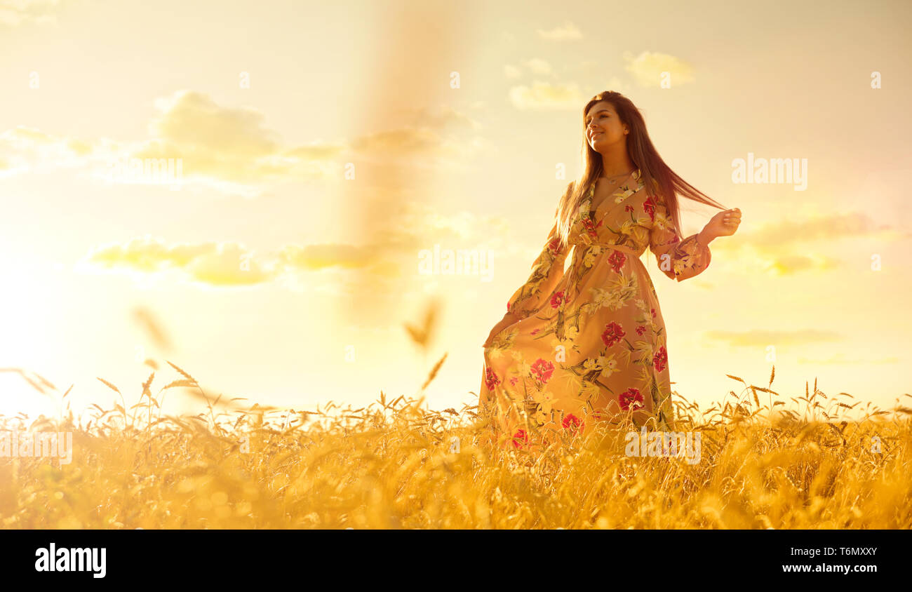 Young girl in wheat field at sunset Stock Photo - Alamy