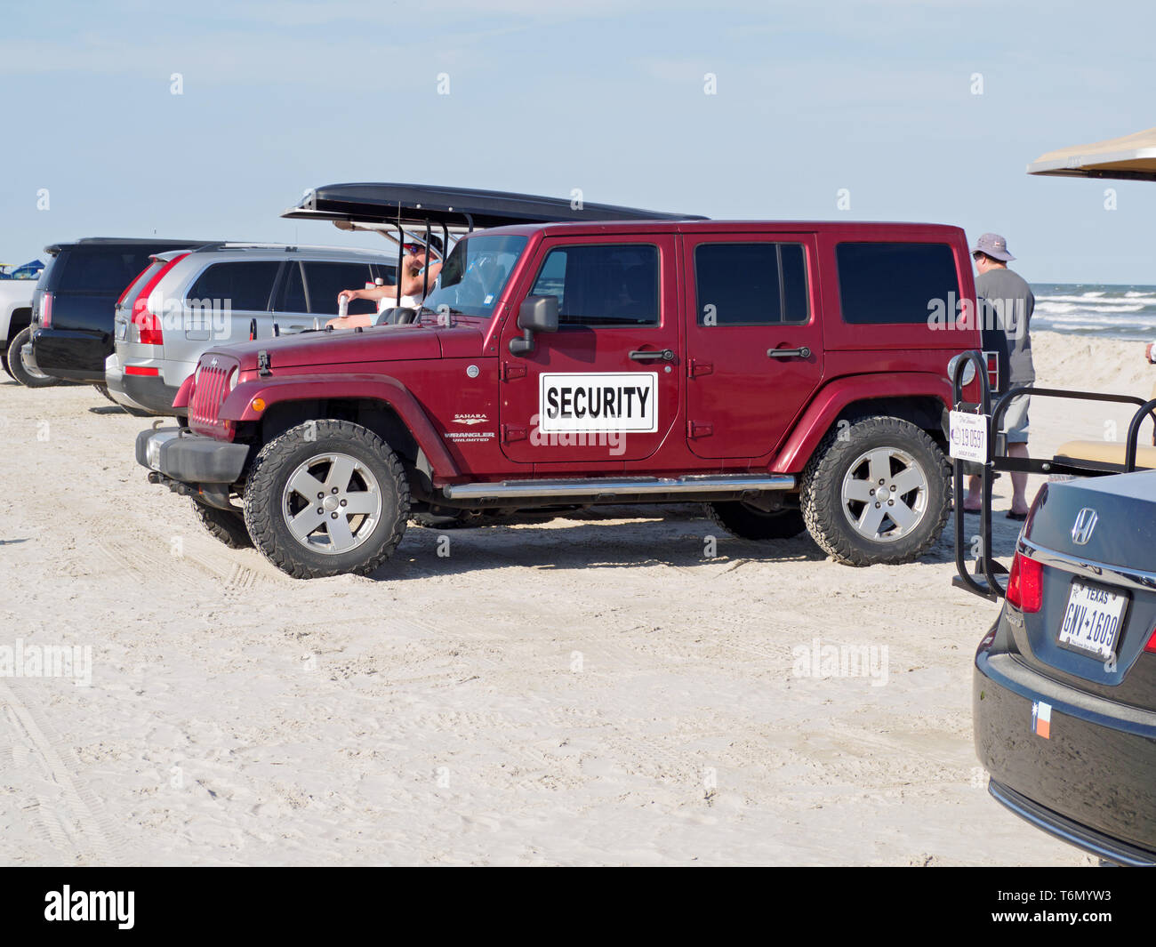 A red Jeep Sahara Wrangler Unlimited with a security sign on the door ...