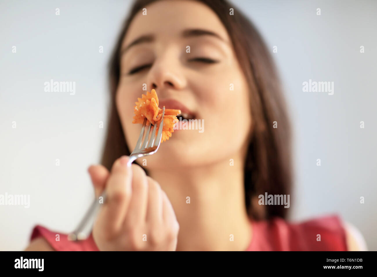 Young woman eating delicious pasta, closeup Stock Photo - Alamy