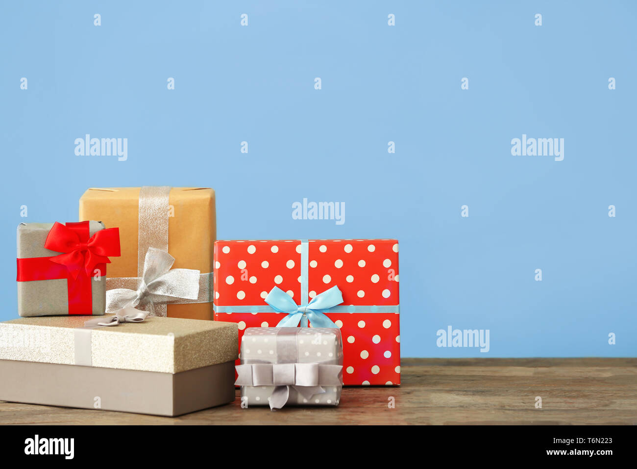 Beautiful gift boxes on table against color background Stock Photo - Alamy