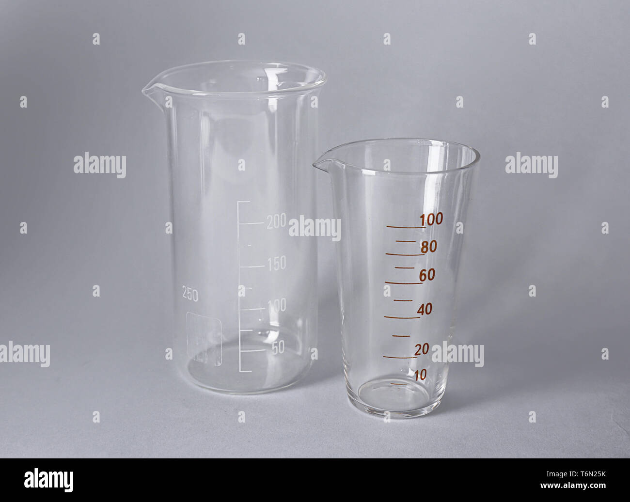 Glass beakers on light background Stock Photo - Alamy