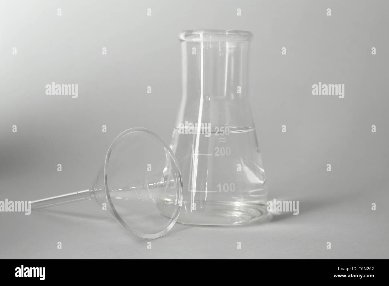 Test flask with water and glass funnel on light background Stock Photo ...