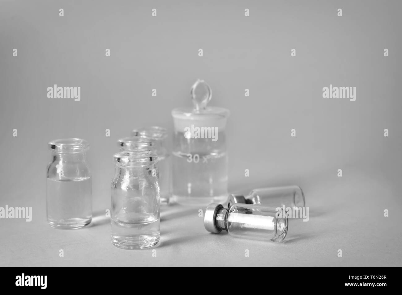 Small glass bottles on light background Stock Photo - Alamy