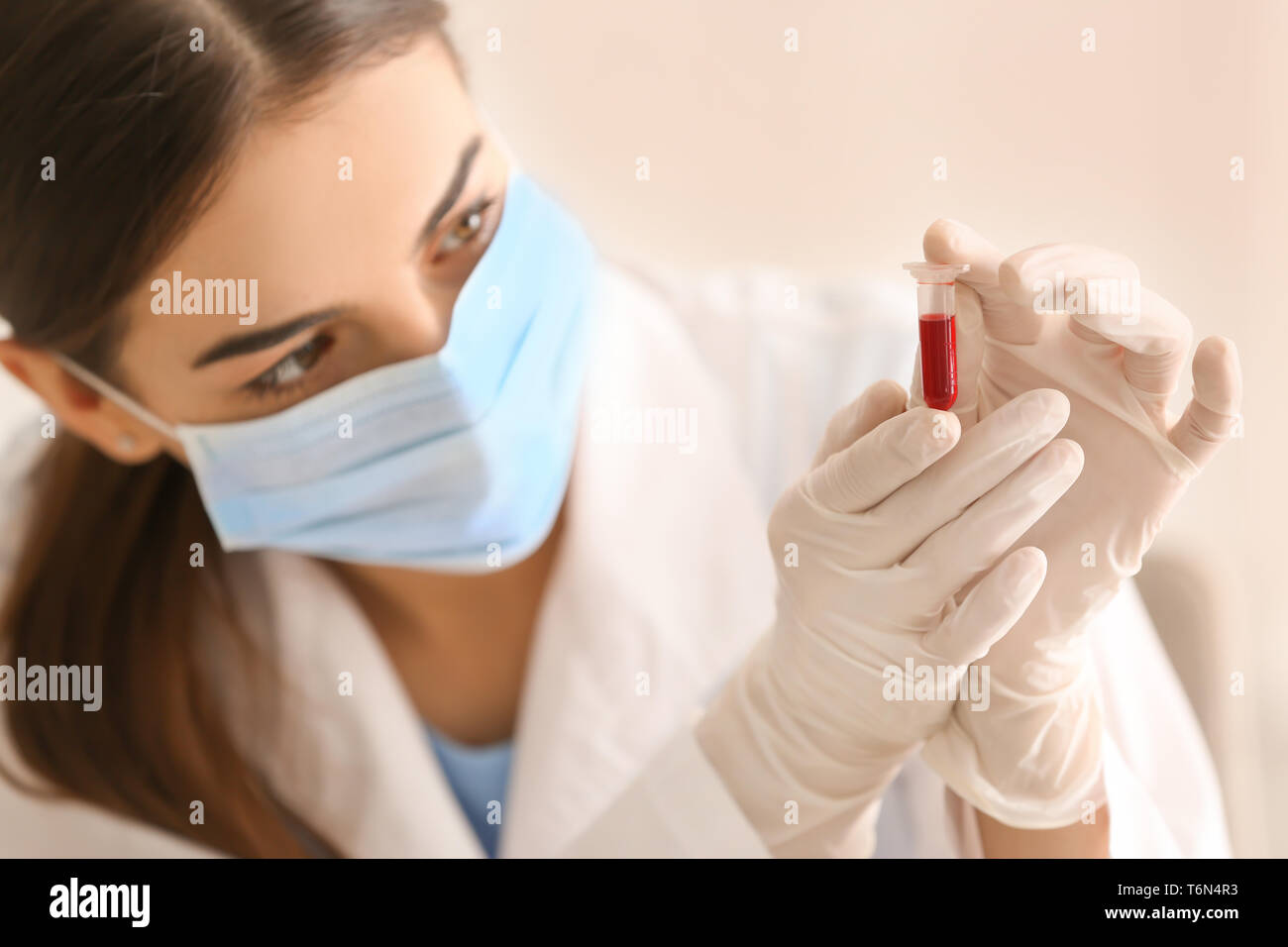Female scientist holding test tube with color sample in laboratory ...