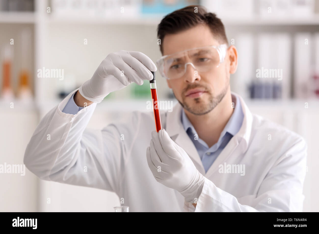 Scientist holding test tube with color sample in laboratory Stock Photo ...