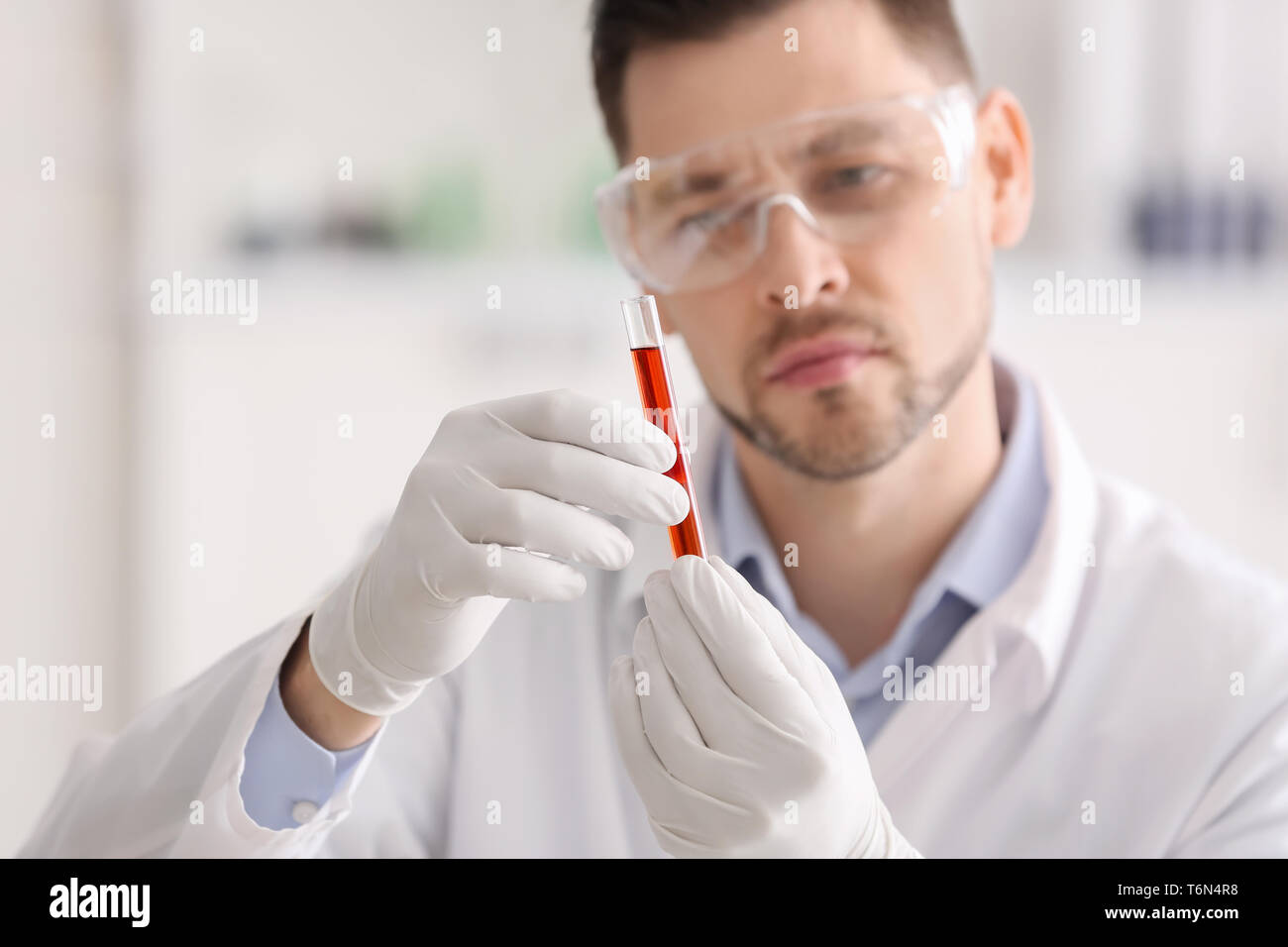 Scientist holding test tube with color sample in laboratory Stock Photo ...