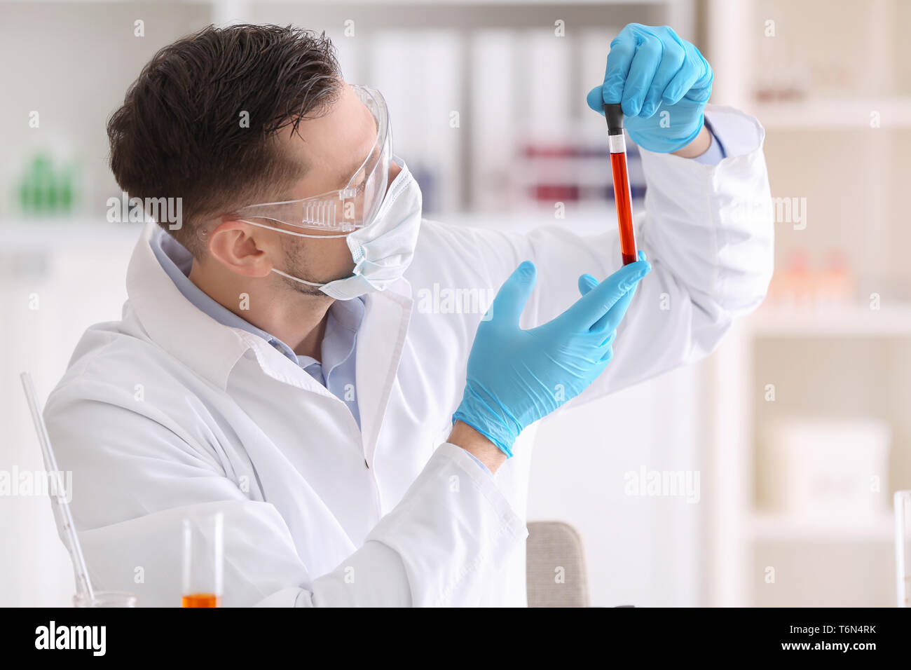 Scientist holding test tube with color sample in laboratory Stock Photo ...