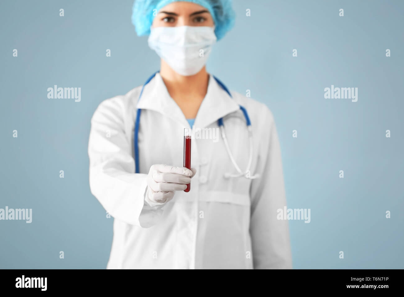 Lab worker holding test tube with blood sample on color background ...