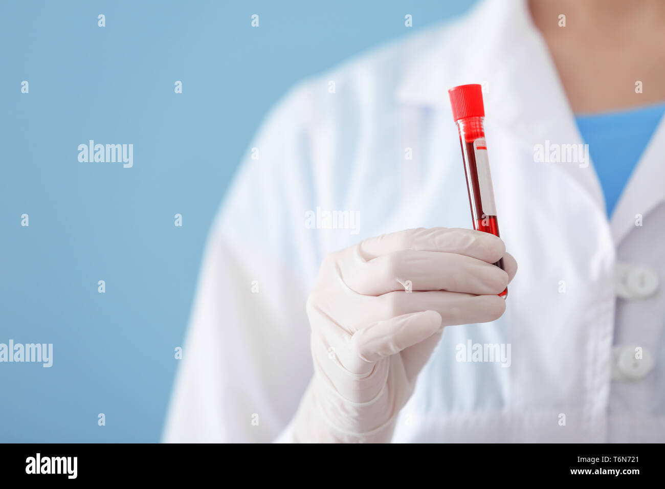Lab worker holding test tube with blood sample on color background ...