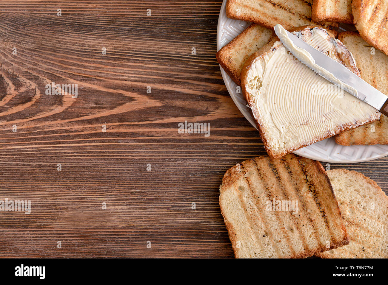 Tasty toasted bread with butter on wooden background, top view Stock ...