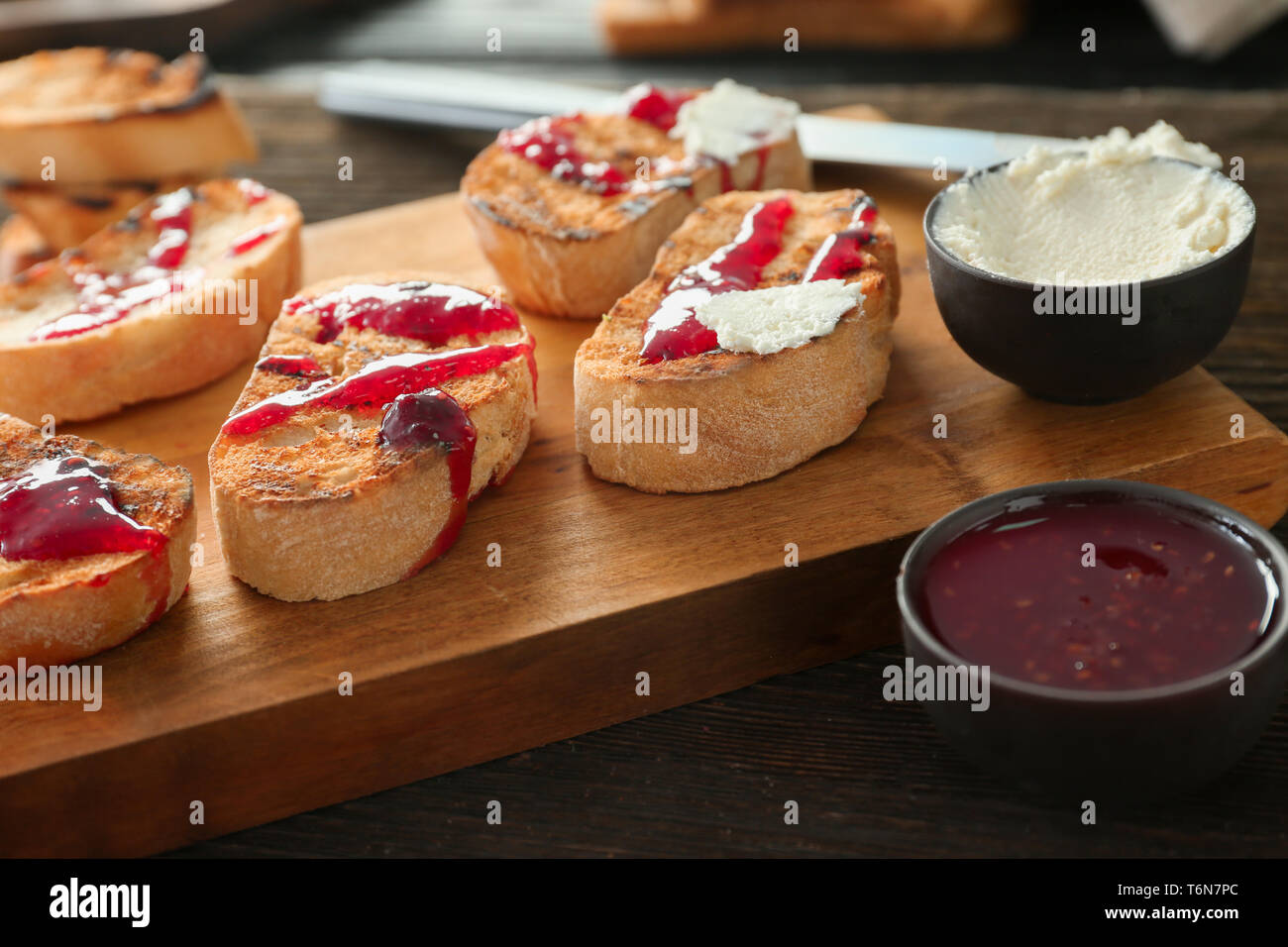 Toasted bread with jam and cream cheese on wooden board Stock Photo - Alamy