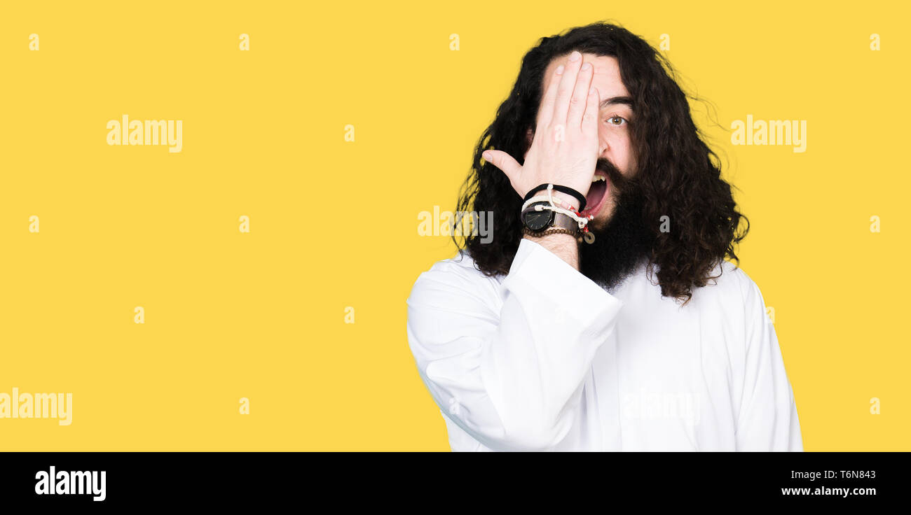 Man wearing Jesus Christ costume covering one eye with hand with ...