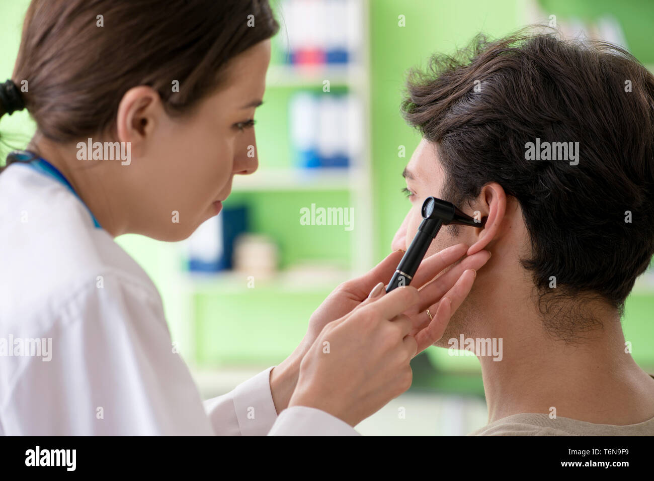 The female doctor checking patient's ear during medical examination ...