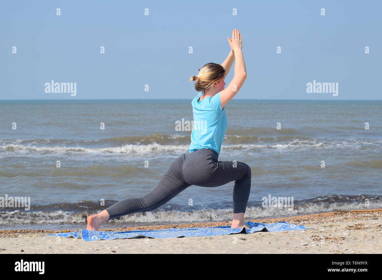 The girl practices yoga by the sea. Exercise gymnastics in the fresh ...