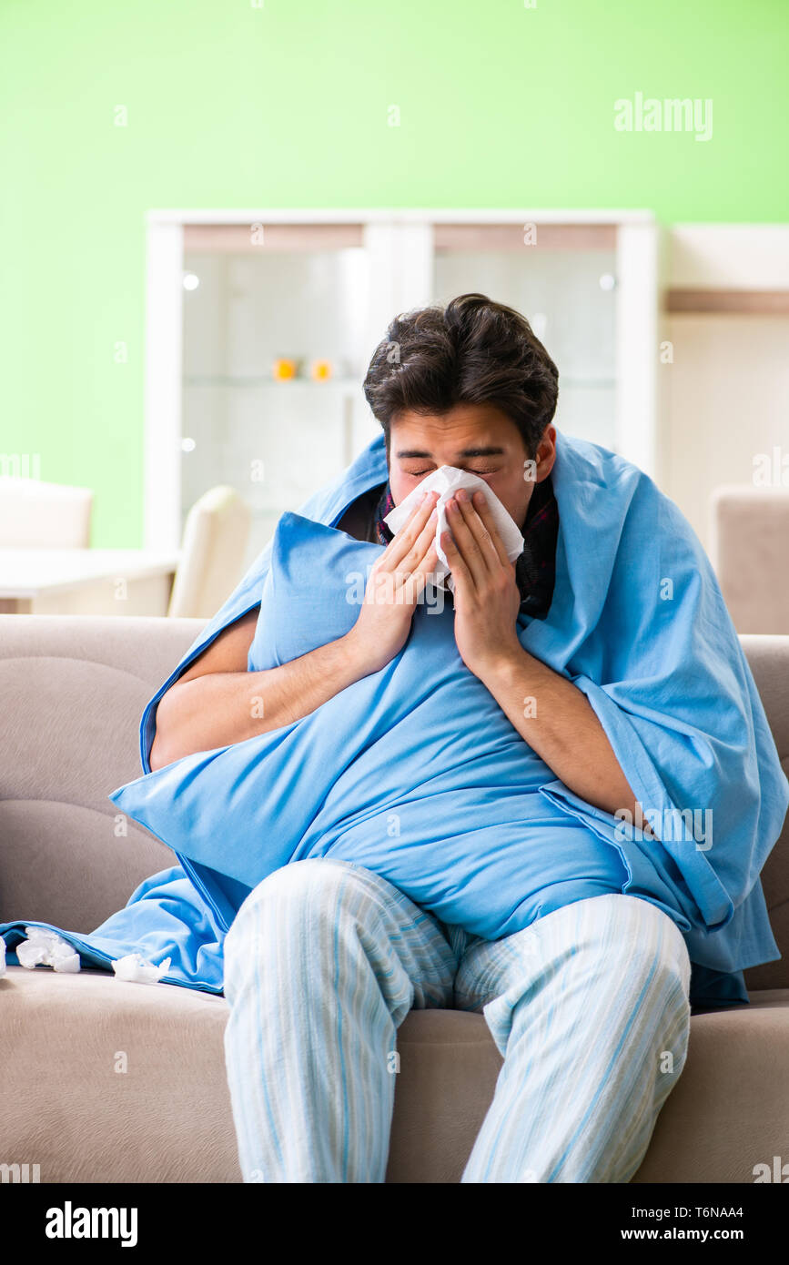The sick young man suffering from flu at home Stock Photo - Alamy