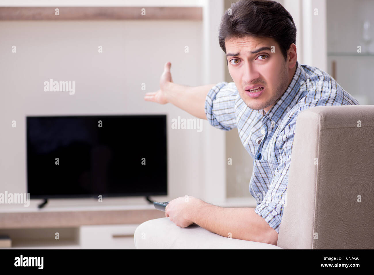 The young man watching tv at home Stock Photo - Alamy