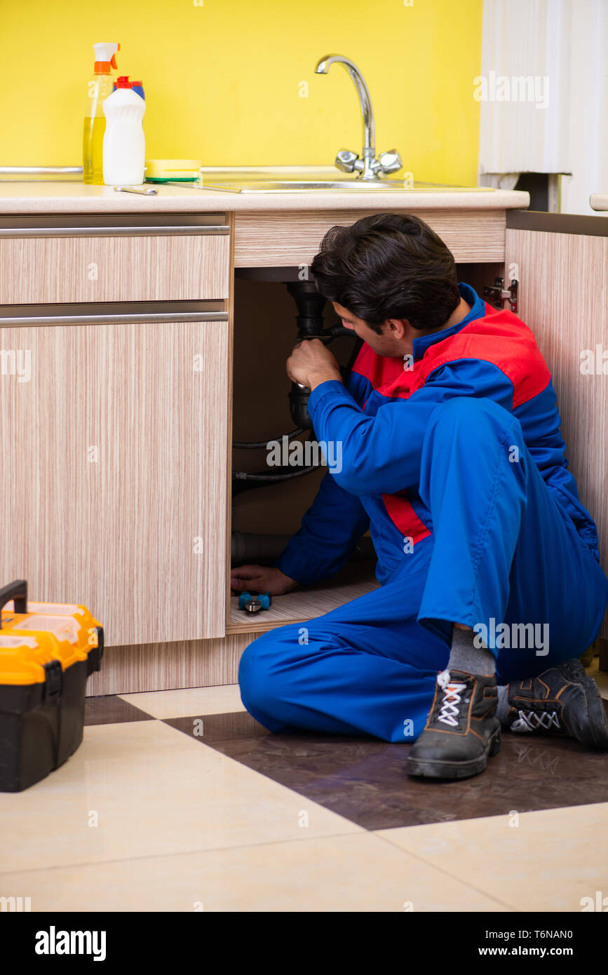 The plumber repairing wash basin at kitchen Stock Photo - Alamy