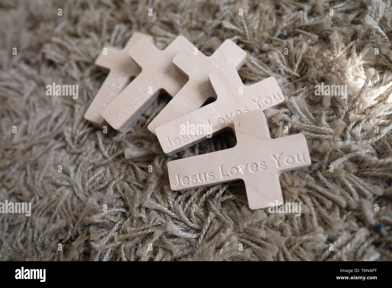 Wooden cross with jesus loves you on carpet Stock Photo - Alamy