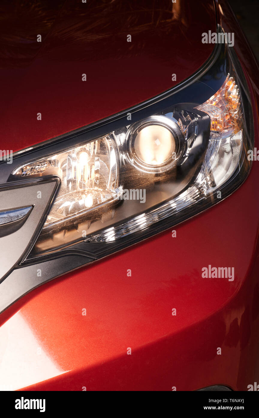 Red car headlight on with yellow lamp close up view Stock Photo - Alamy