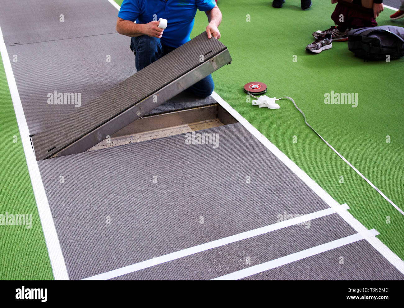 A long jump board is replaced on a long jump, triple jump, runway in an ...