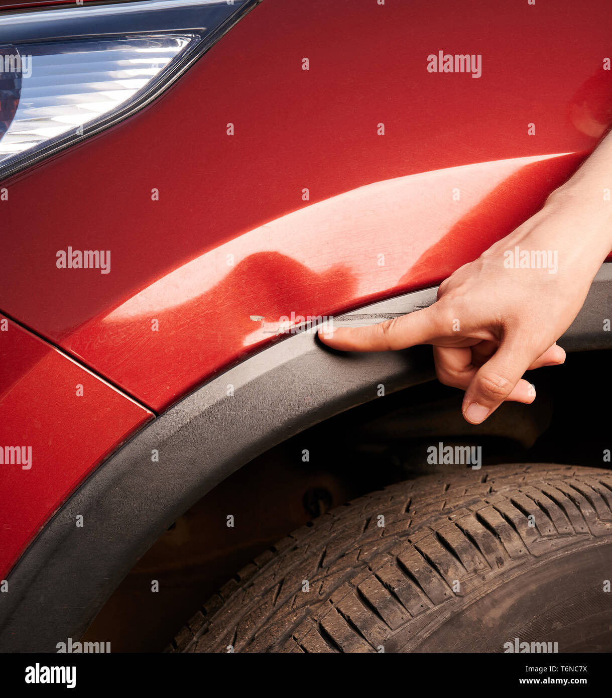 Finger point at car scratch near wheel area Stock Photo - Alamy