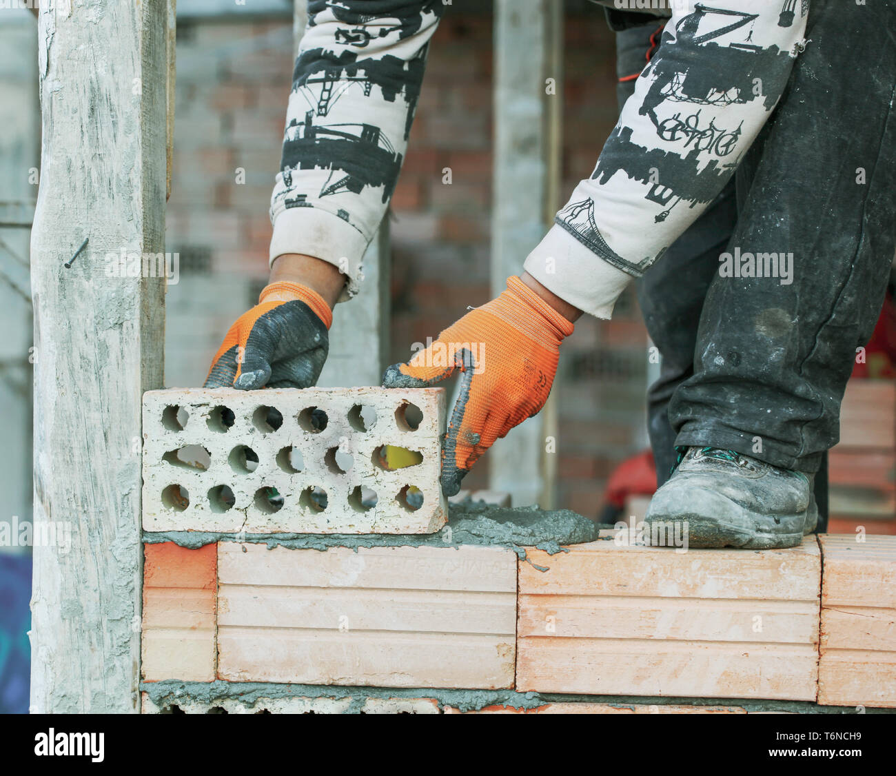 Industrial bricklayer installing bricks on construction site Stock ...