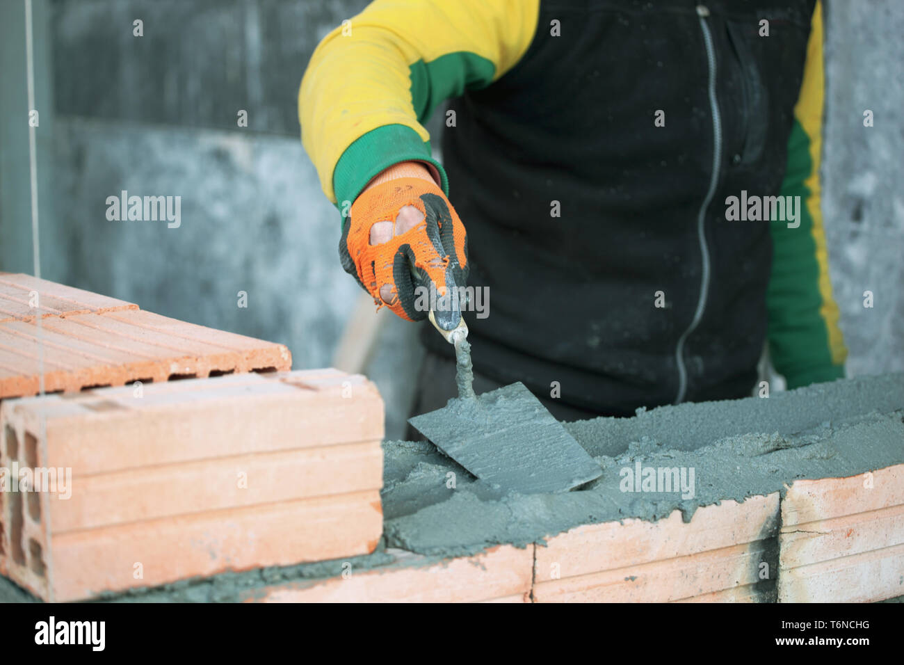 Industrial bricklayer installing bricks on construction site Stock ...