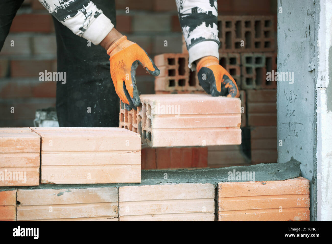 Industrial bricklayer installing bricks on construction site Stock ...