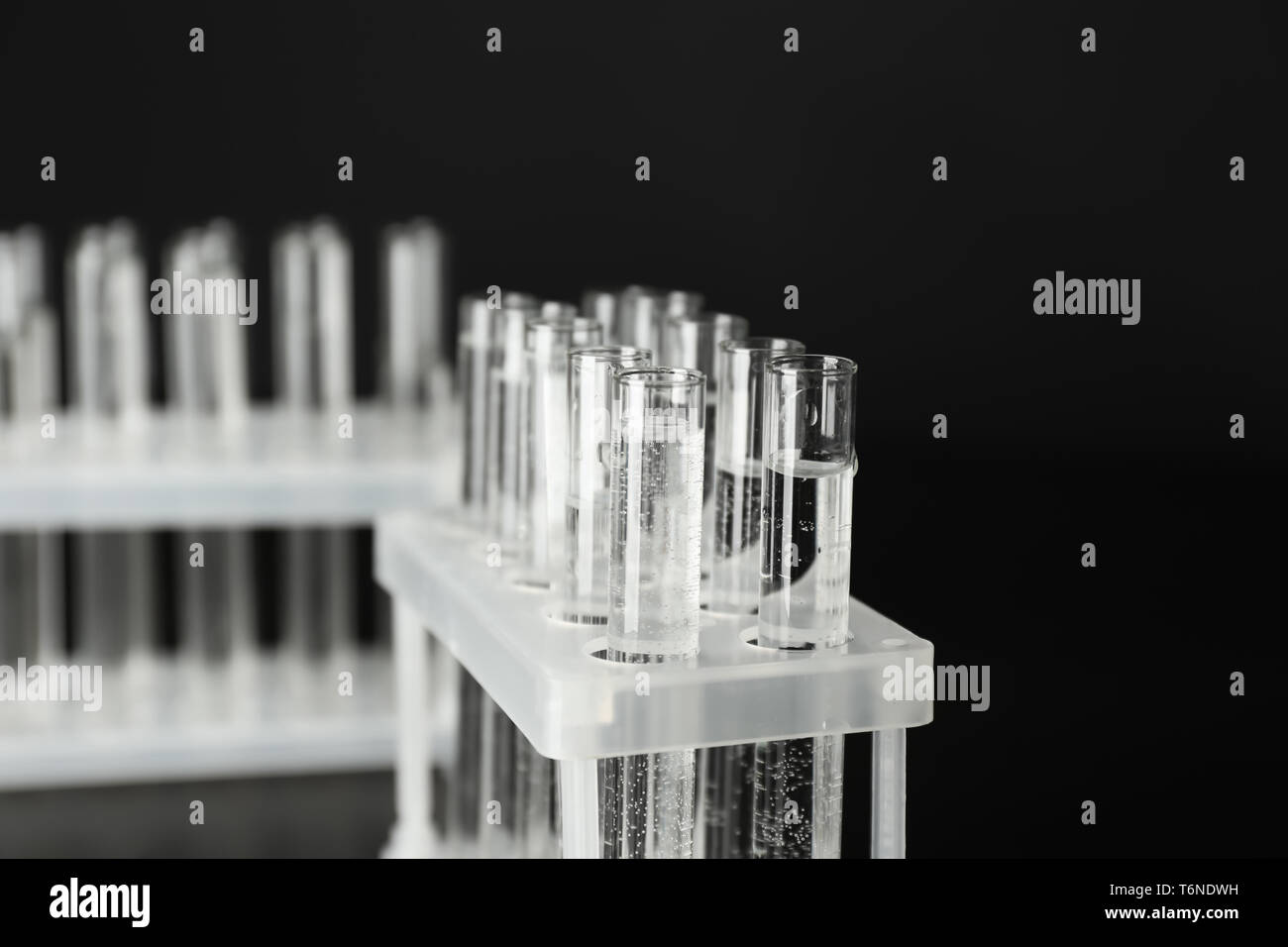 Stand with test tubes on black background Stock Photo - Alamy