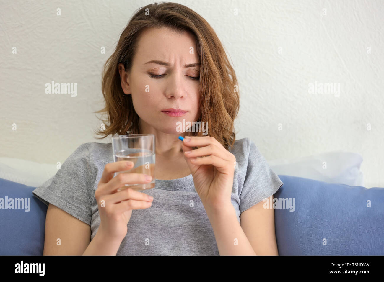 Young woman taking pill in bed Stock Photo - Alamy