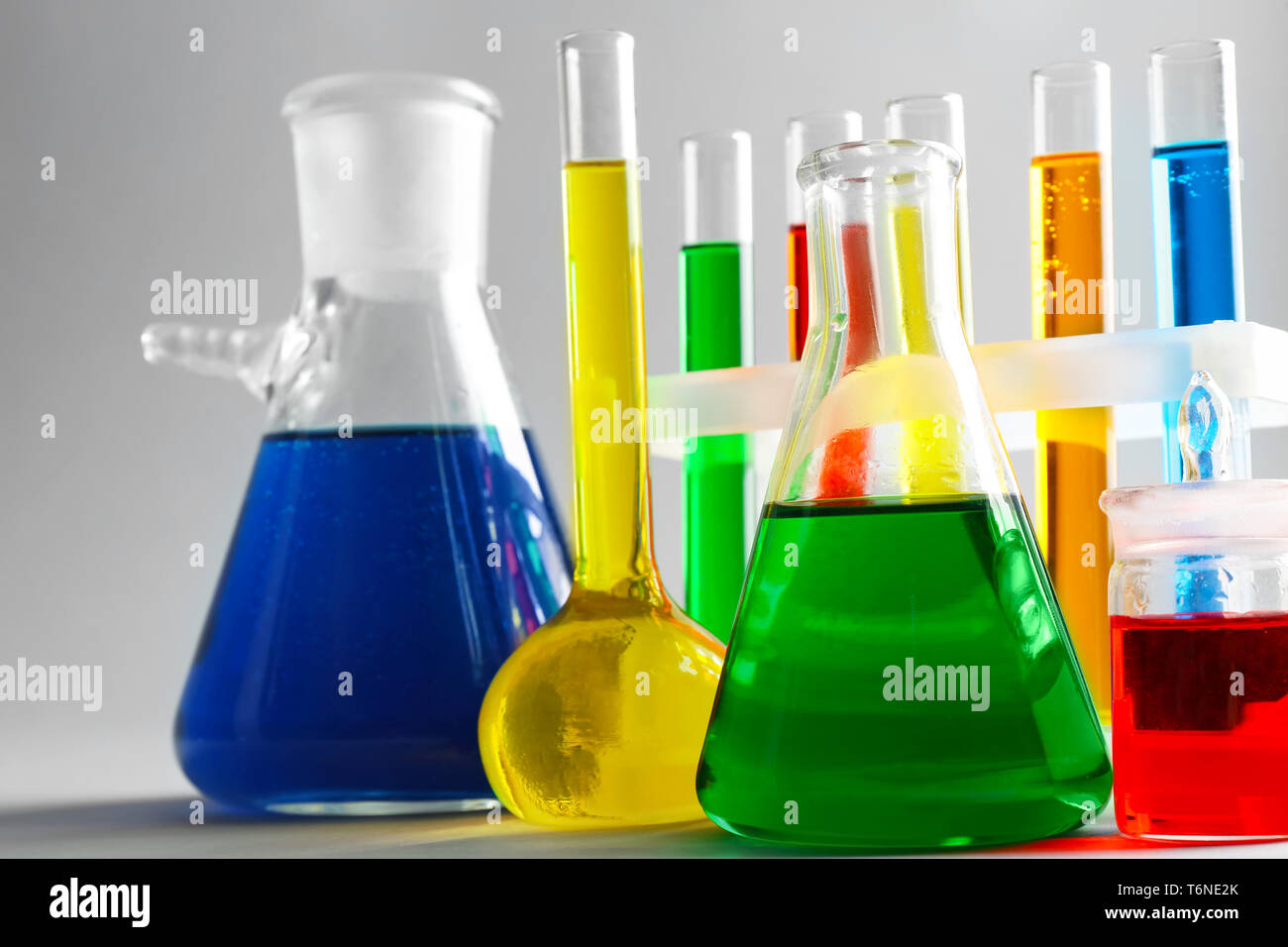 Chemical glassware with colorful samples on light background Stock ...