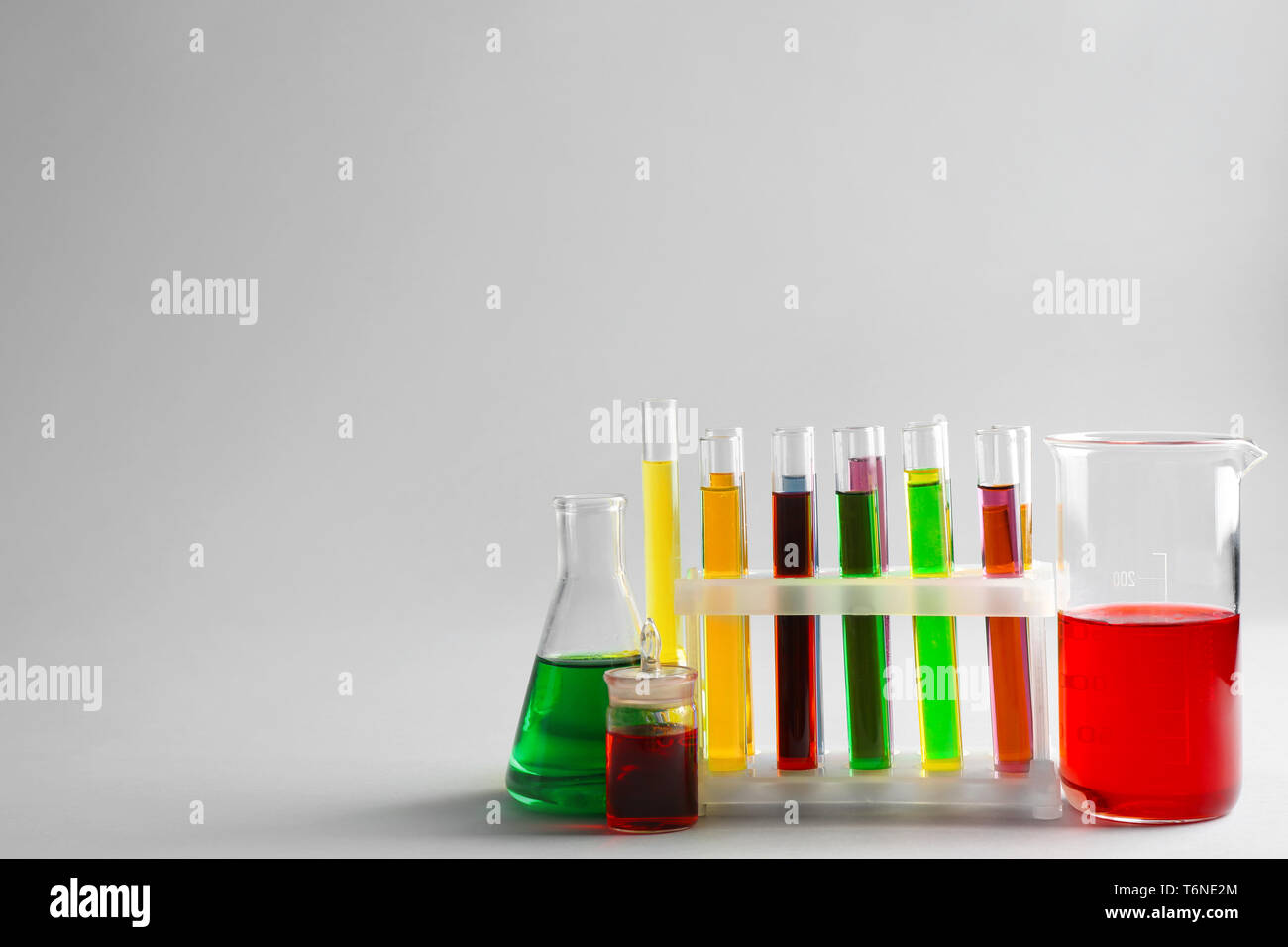 Chemical glassware with colorful samples on light background Stock ...