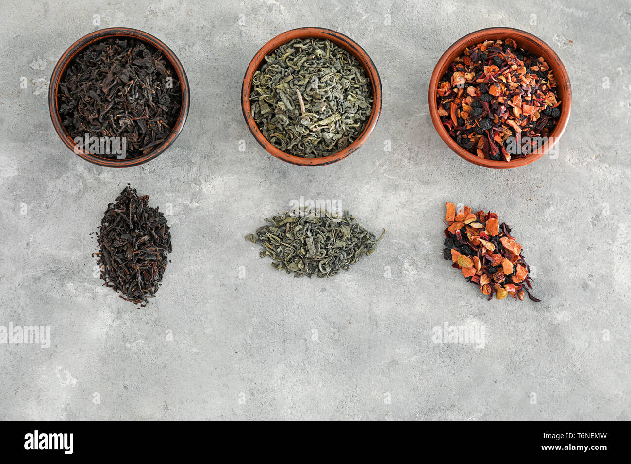 Different types of dry tea leaves on grey background Stock Photo - Alamy