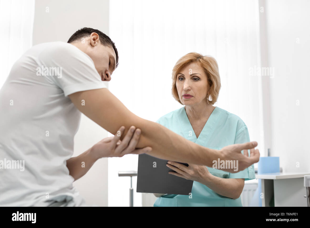 Orthopedist and patient with aching arm in hospital Stock Photo - Alamy