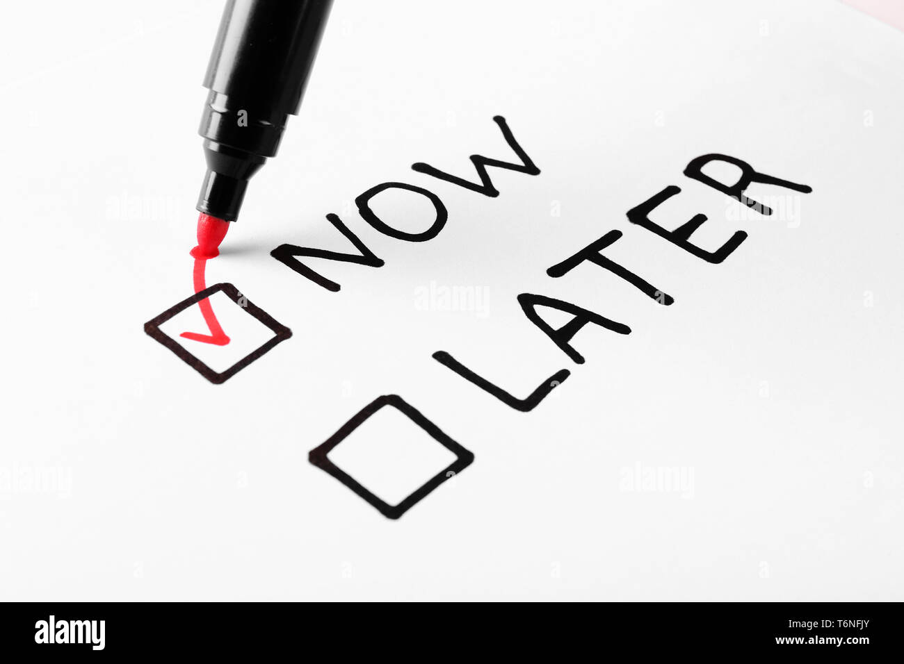 Choosing word NOW instead of LATER on white background Stock Photo - Alamy