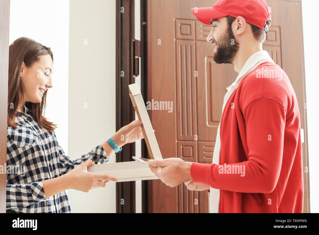 Young woman receiving order from courier. Food delivery service Stock ...