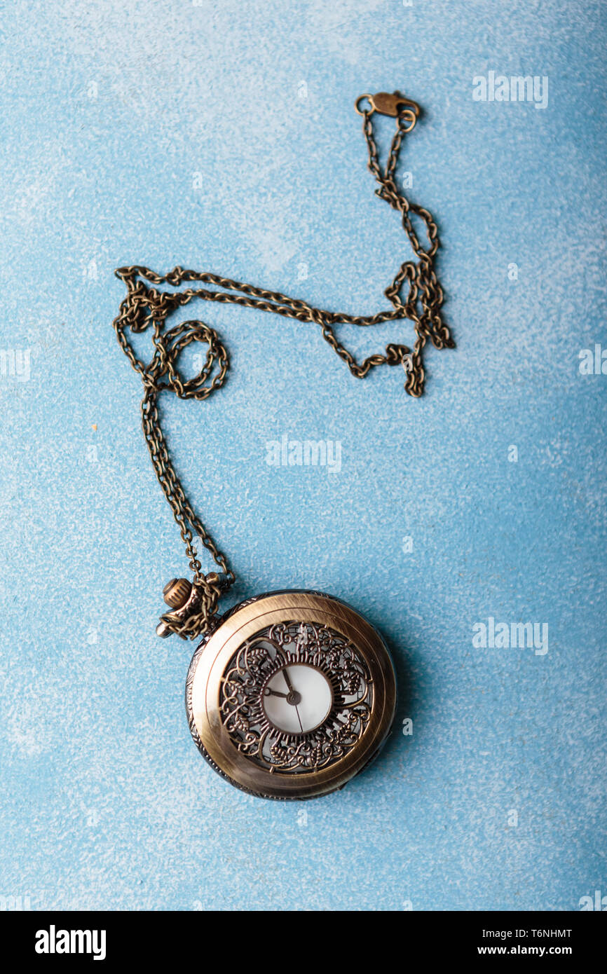 Pocket watch on blue background Stock Photo - Alamy