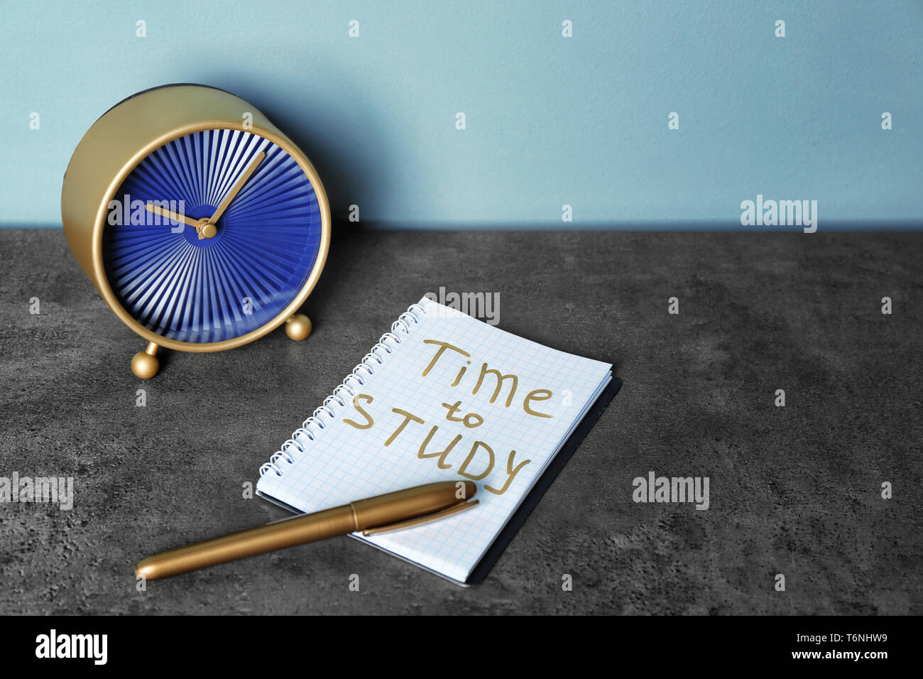 Alarm clock and notebook with written text TIME TO STUDY on table. Time ...