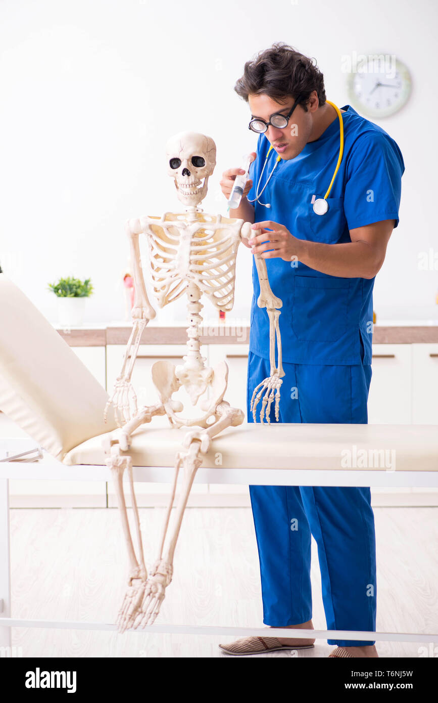 Funny doctor with skeleton in hospital Stock Photo - Alamy
