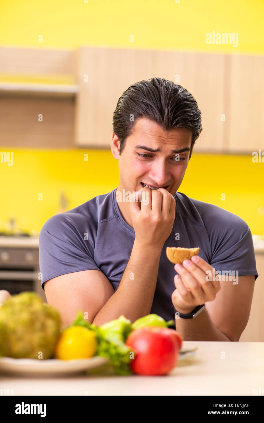 Man having hard choice between healthy and unhealthy food Stock Photo ...