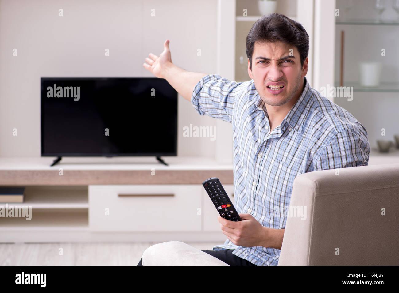 Man trying to fix broken tv Stock Photo - Alamy