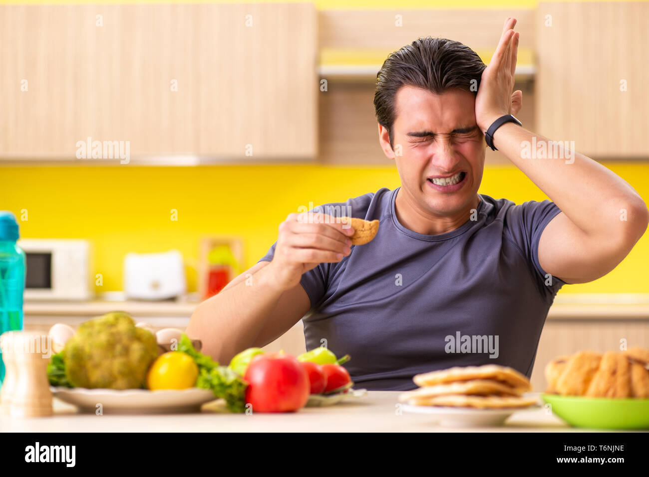 Man having hard choice between healthy and unhealthy food Stock Photo ...