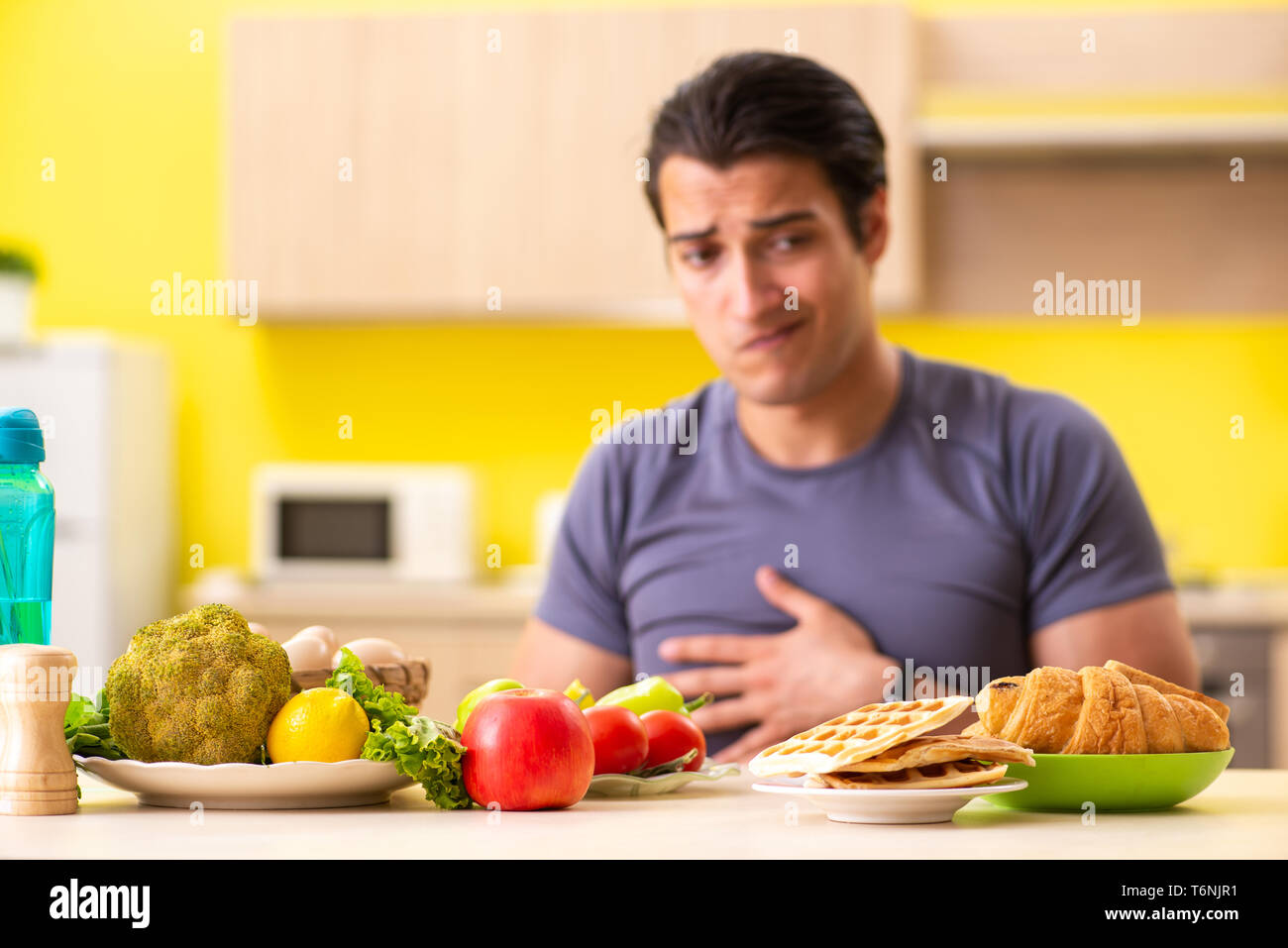 Man having hard choice between healthy and unhealthy food Stock Photo ...