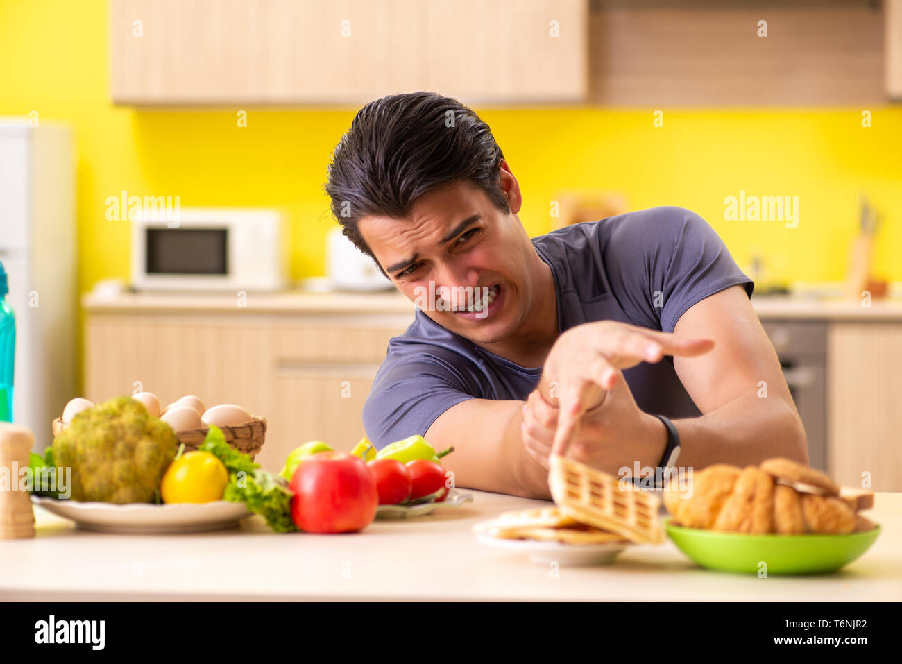 Man having hard choice between healthy and unhealthy food Stock Photo ...